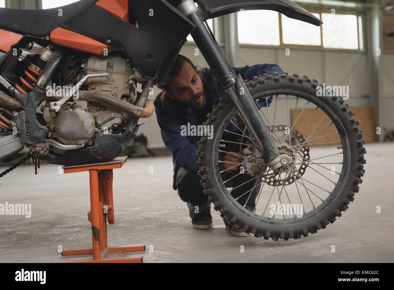 Mechanic repairing motorcycle Stock Photo - Alamy