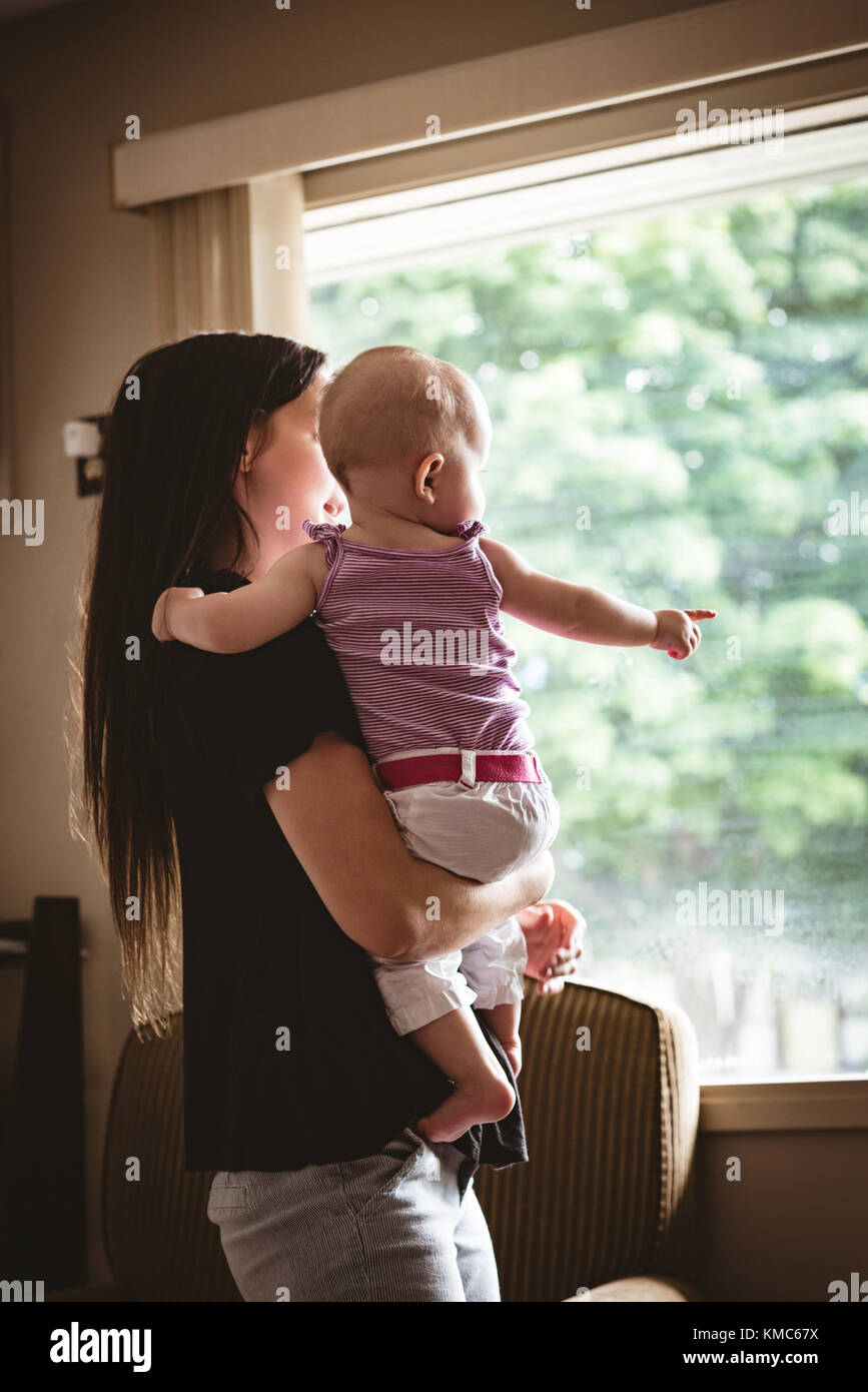 Mother and baby looking through window Stock Photo - Alamy