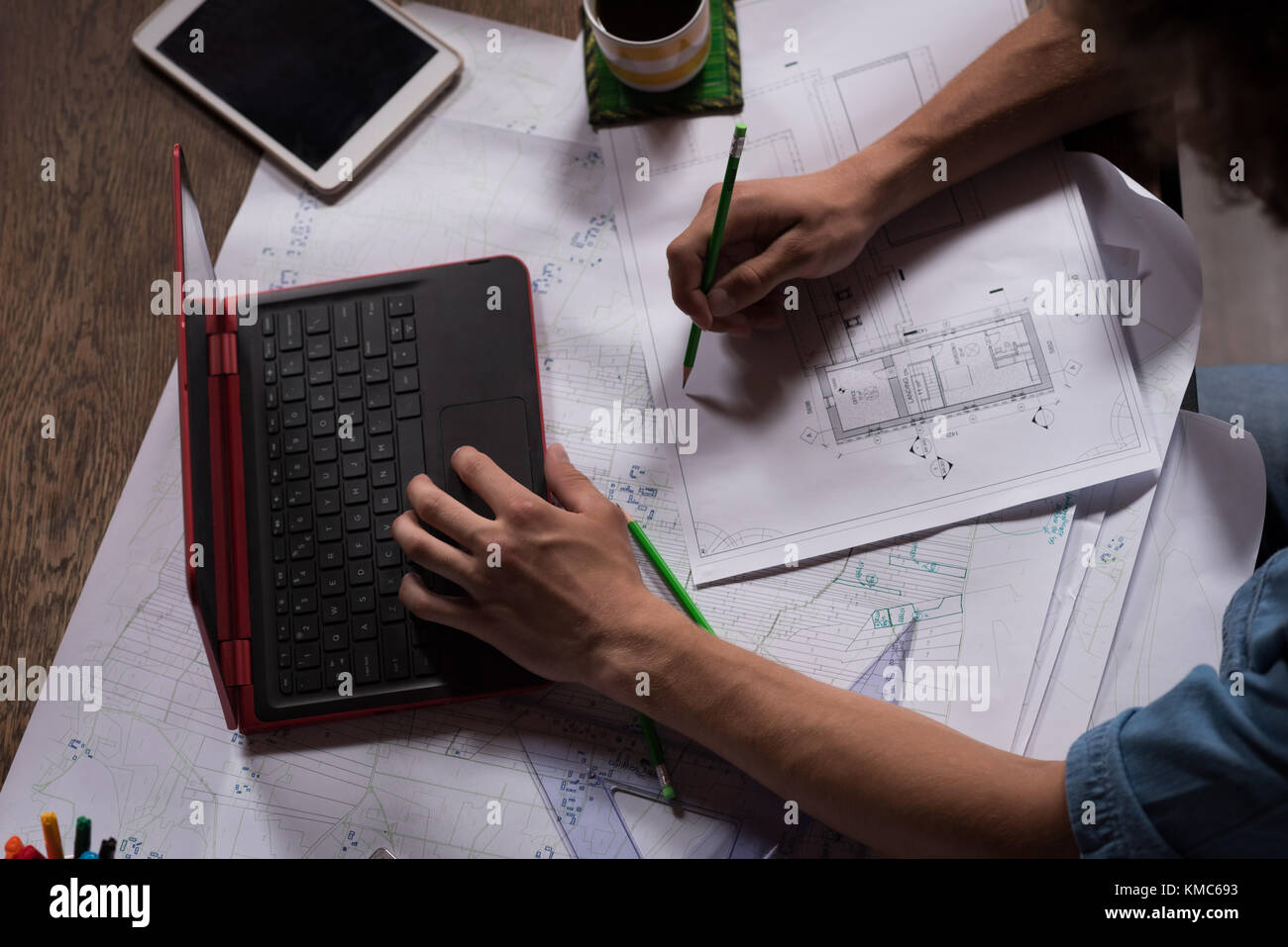 Male graphic designer working on laptop and blueprint Stock Photo - Alamy