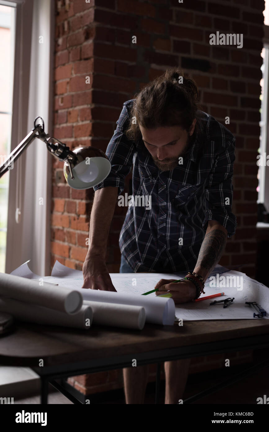 Male graphic designer working on blueprint Stock Photo - Alamy