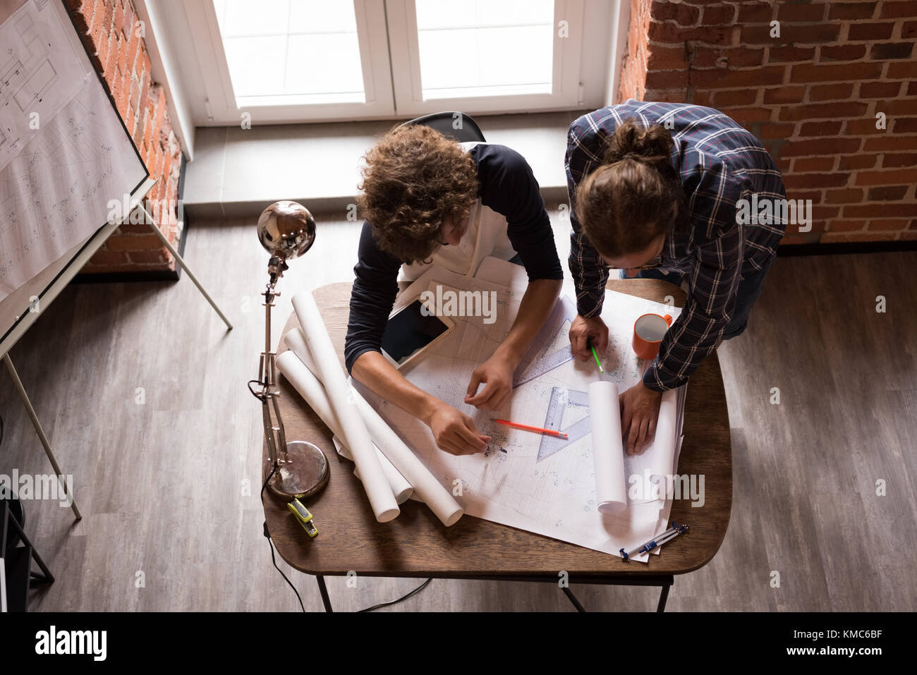 Male graphic designers working on blueprint Stock Photo - Alamy