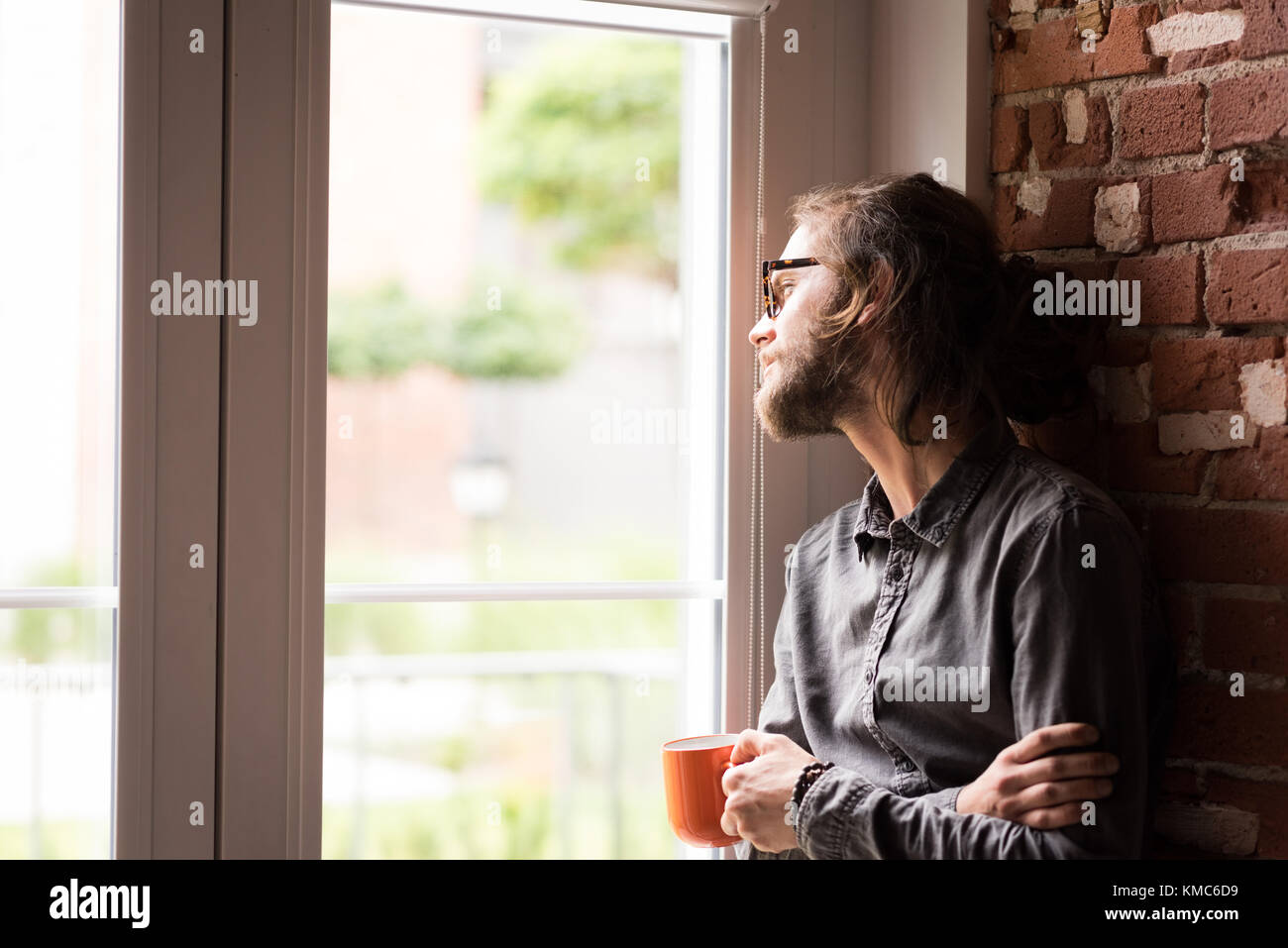 Man looking through window while having coffee Stock Photo - Alamy