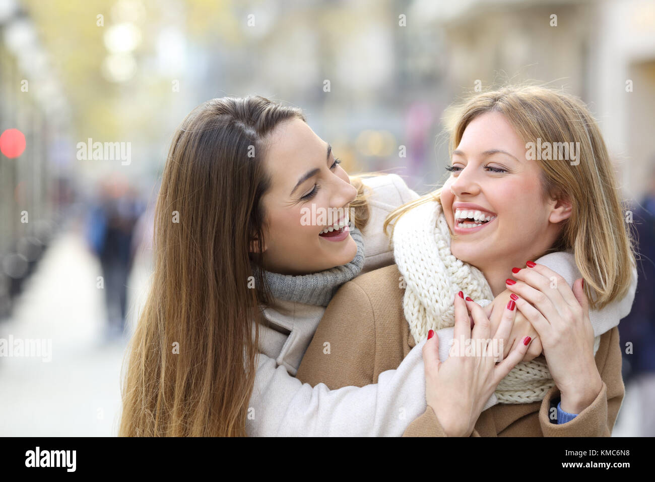 Two happy friends joking and laughing on the street in winter Stock ...