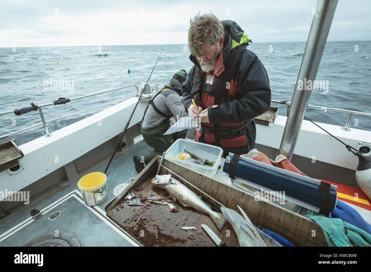 Fisherman writing in paper Stock Photo - Alamy