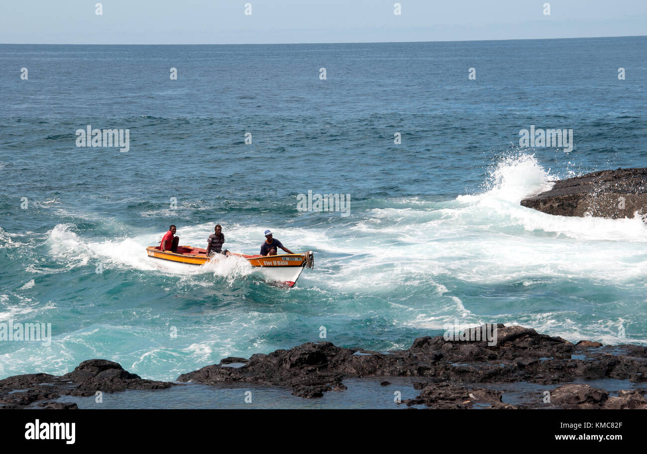 A small fishing boat overcomes strong waves to reach port and safety in ...