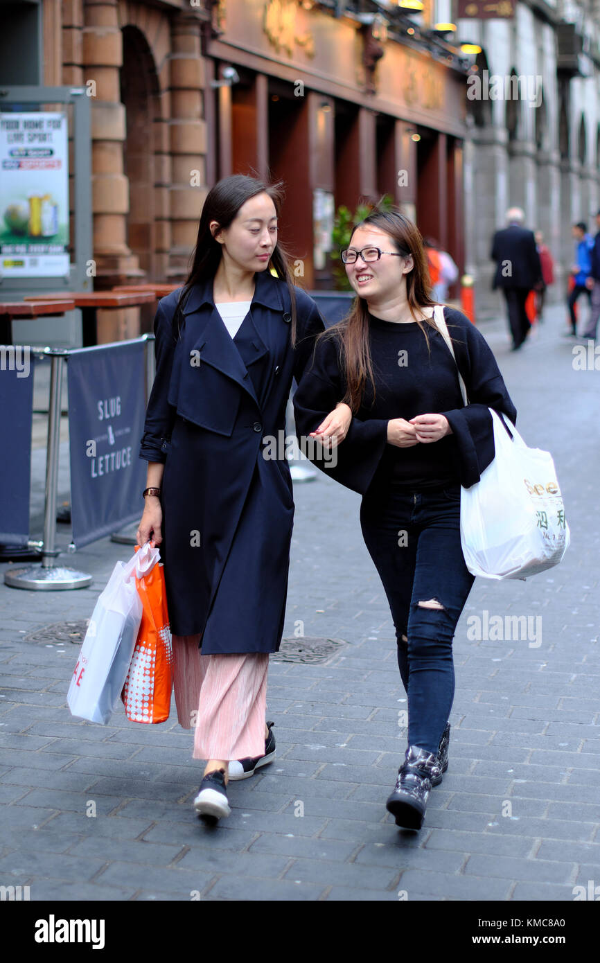 Two Chinese women walking together with arms linked in Chinatown, Soho ...