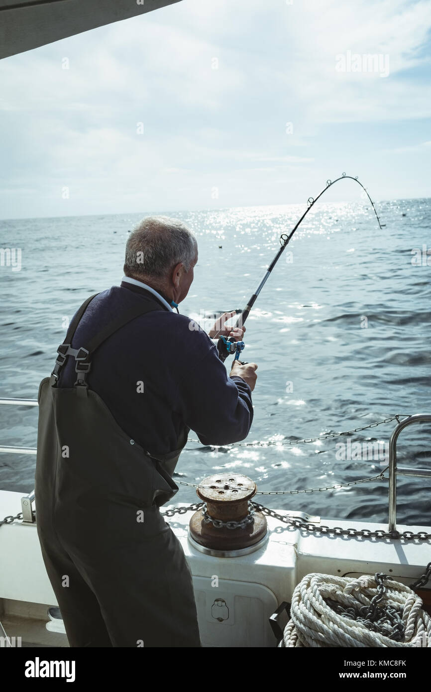 Fisherman fishing from the boat Stock Photo - Alamy