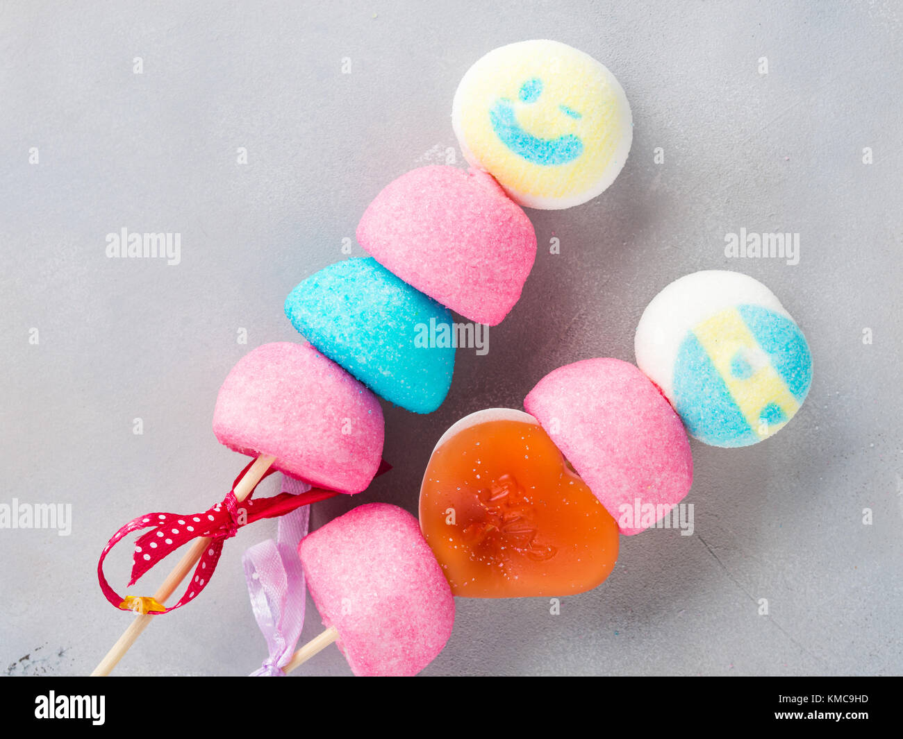 Colorful marshmallows cake pops on wooden sticks with smiling faces ...