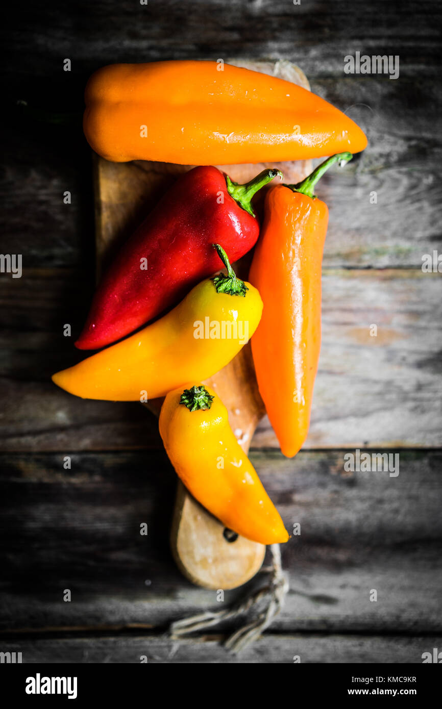 Colorful peppers on rustic background Stock Photo - Alamy