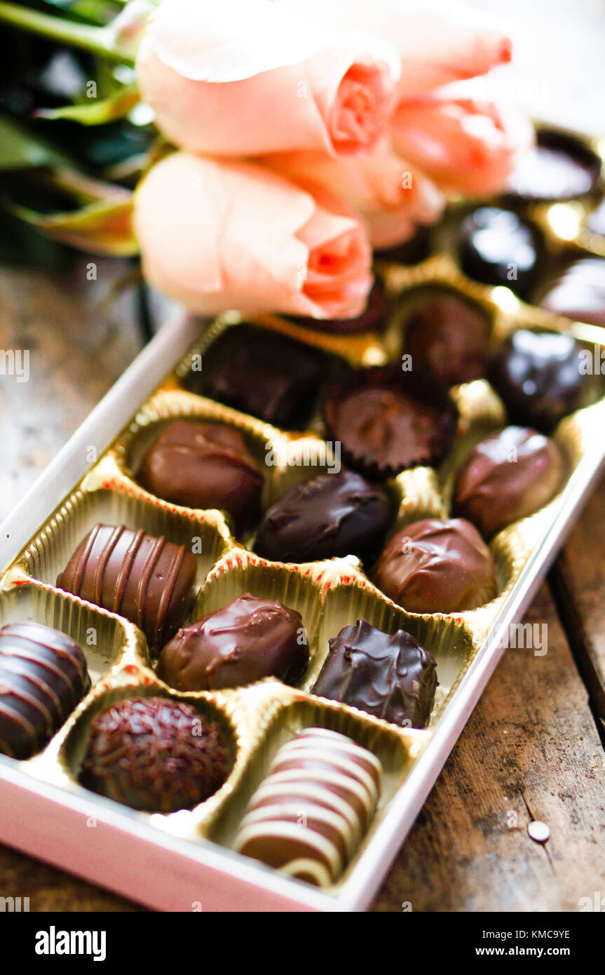Delicious Chocolate Candies With A Bouquet Of Roses Stock Photo - Alamy