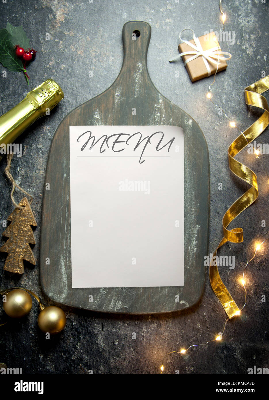 Menu on top of a rustic chopping board with decorations and champagne ...