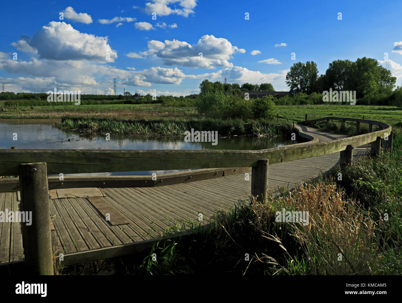 A beautiful countryside scene with a wooden pathway around a lake Stock ...