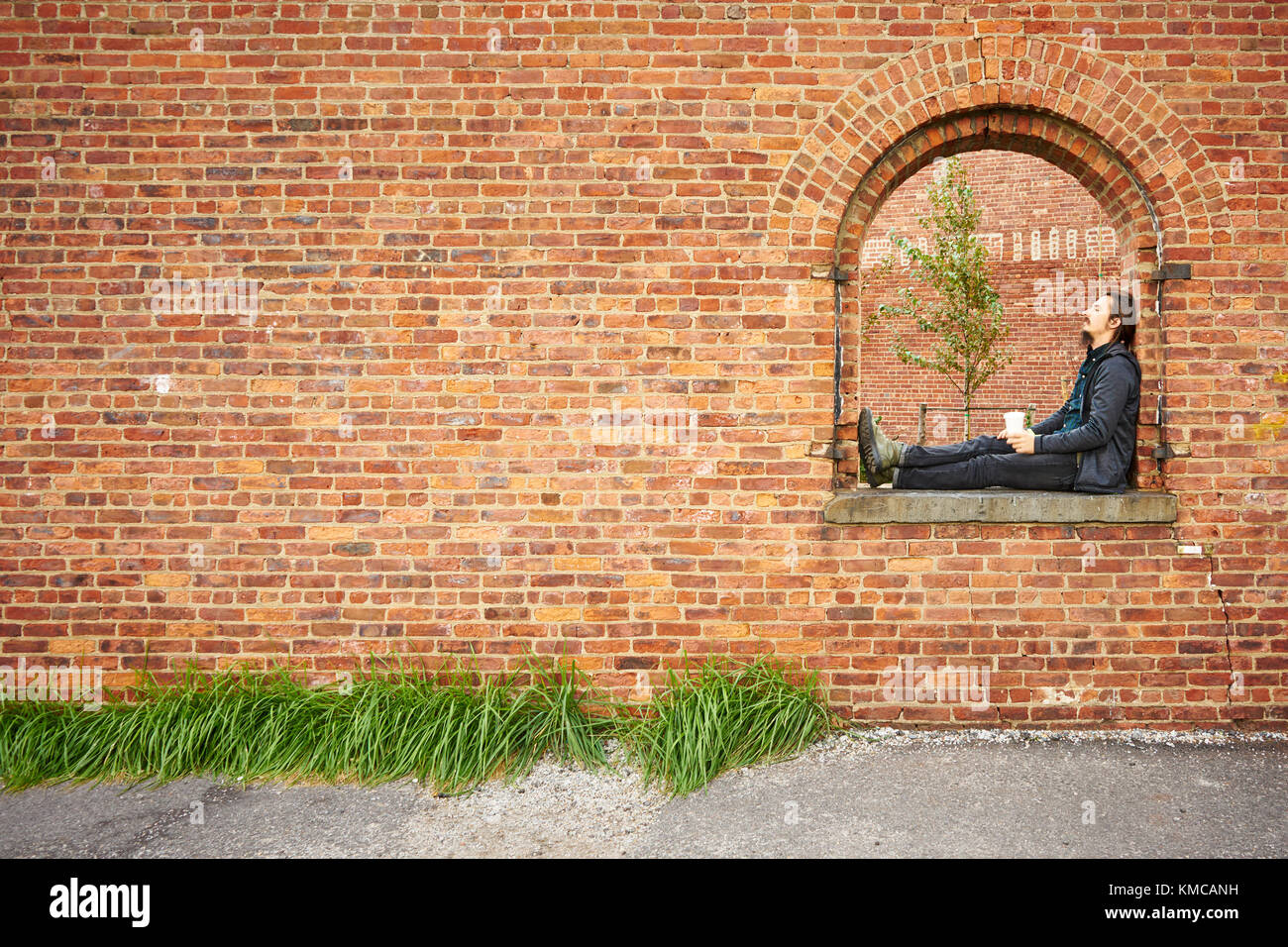 Man sitting on a brick wall hi-res stock photography and images - Alamy