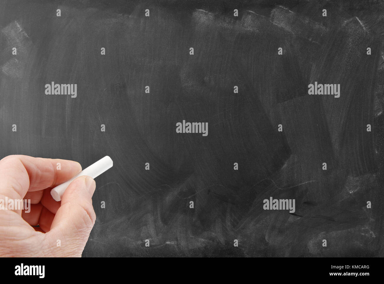 Hand holding piece of chalk to blank blackboard Stock Photo - Alamy