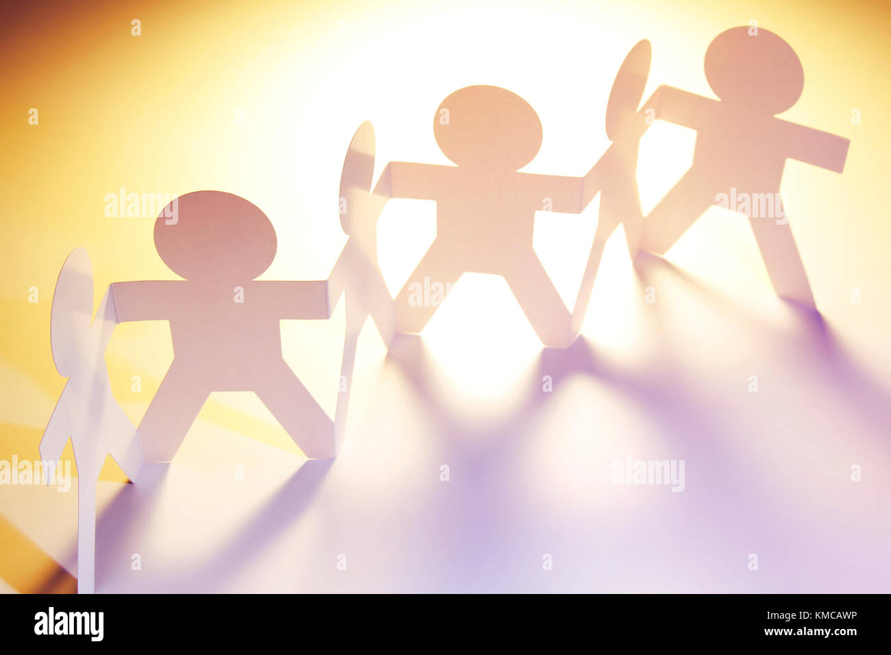 Team of paper chain people in a row holding hands Stock Photo - Alamy