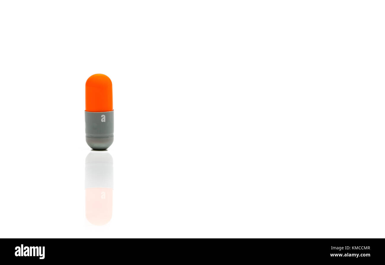 Orange, gray antibiotics capsule pill isolated on white background with ...