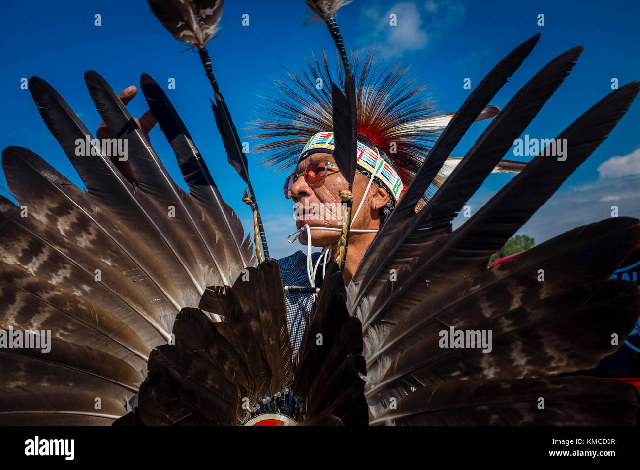 a man straitens the feathers of his headdress prior to a dance Stock ...