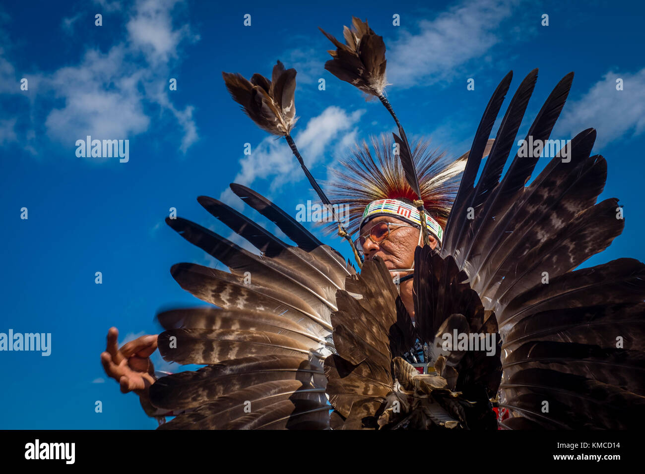 a man straitens the feathers of his headdress prior to a dance Stock ...