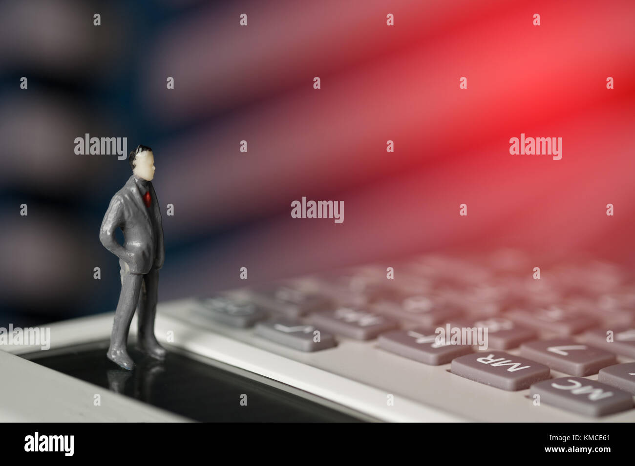Figure miniature businessman or small people standing on calculator for ...