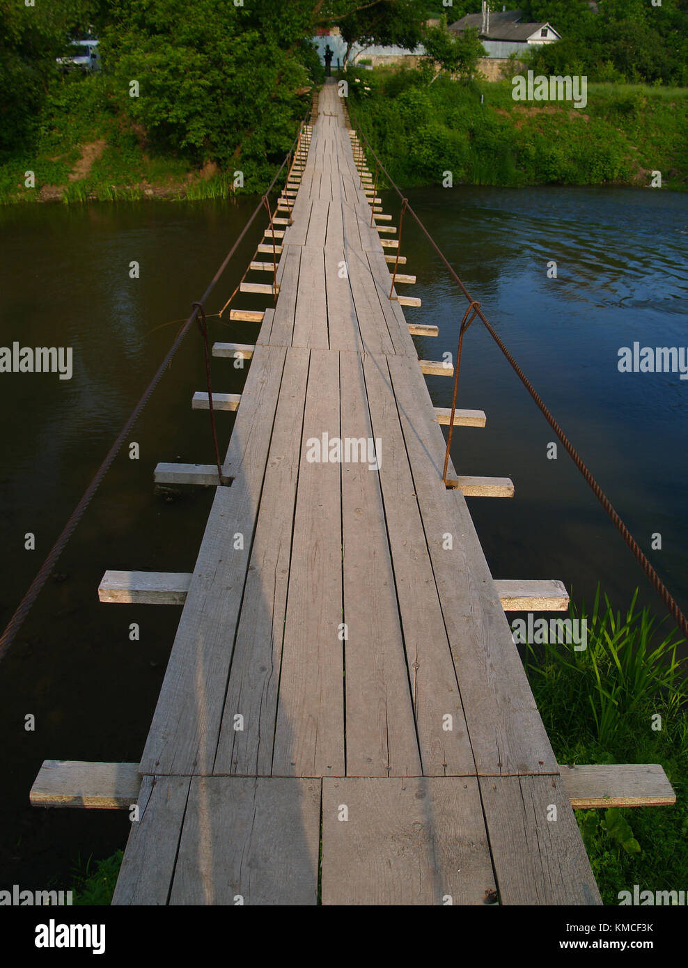 Bridge across the river: a shaky wooden crossing across a small river ...