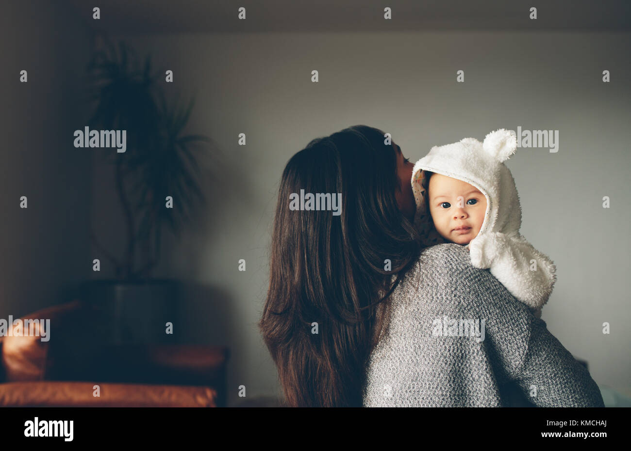 Young woman at home holding her cute little son. Mother carries the child in her arms Stock ...