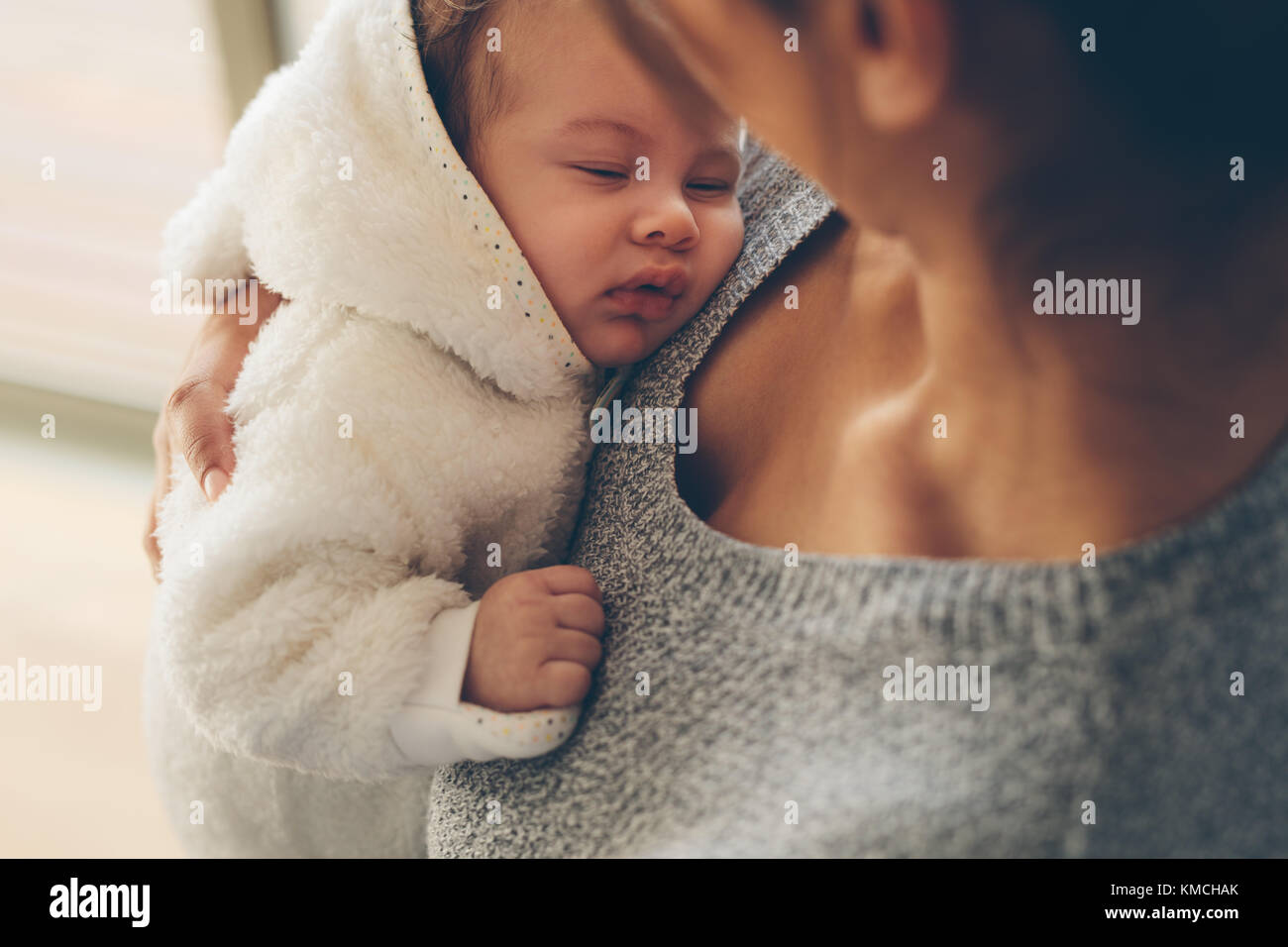 Close up of woman carrying her newborn baby boy. Cute little boy sleeping in his mother's arms ...