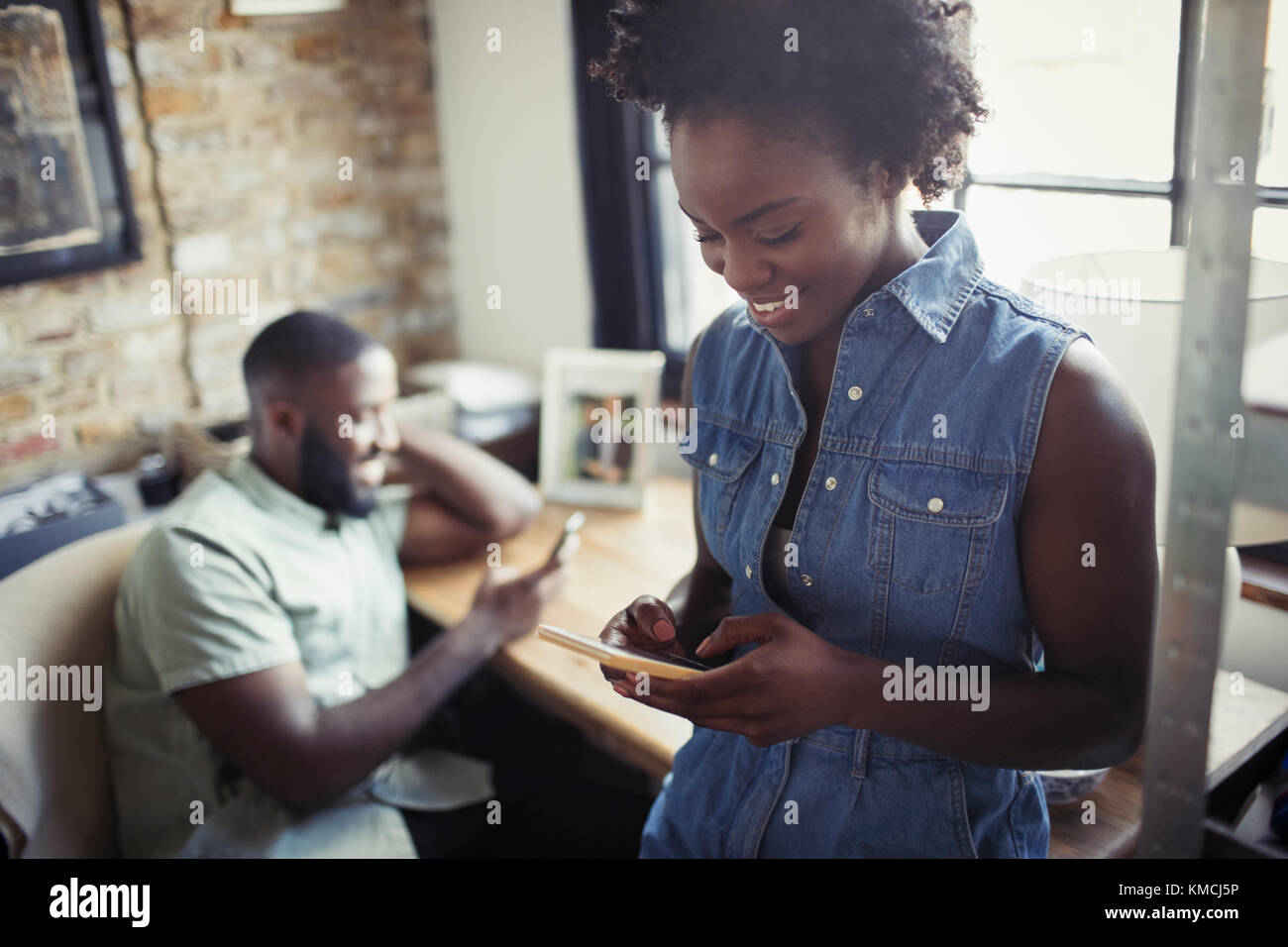 Smiling woman texting phone home hi-res stock photography and images ...
