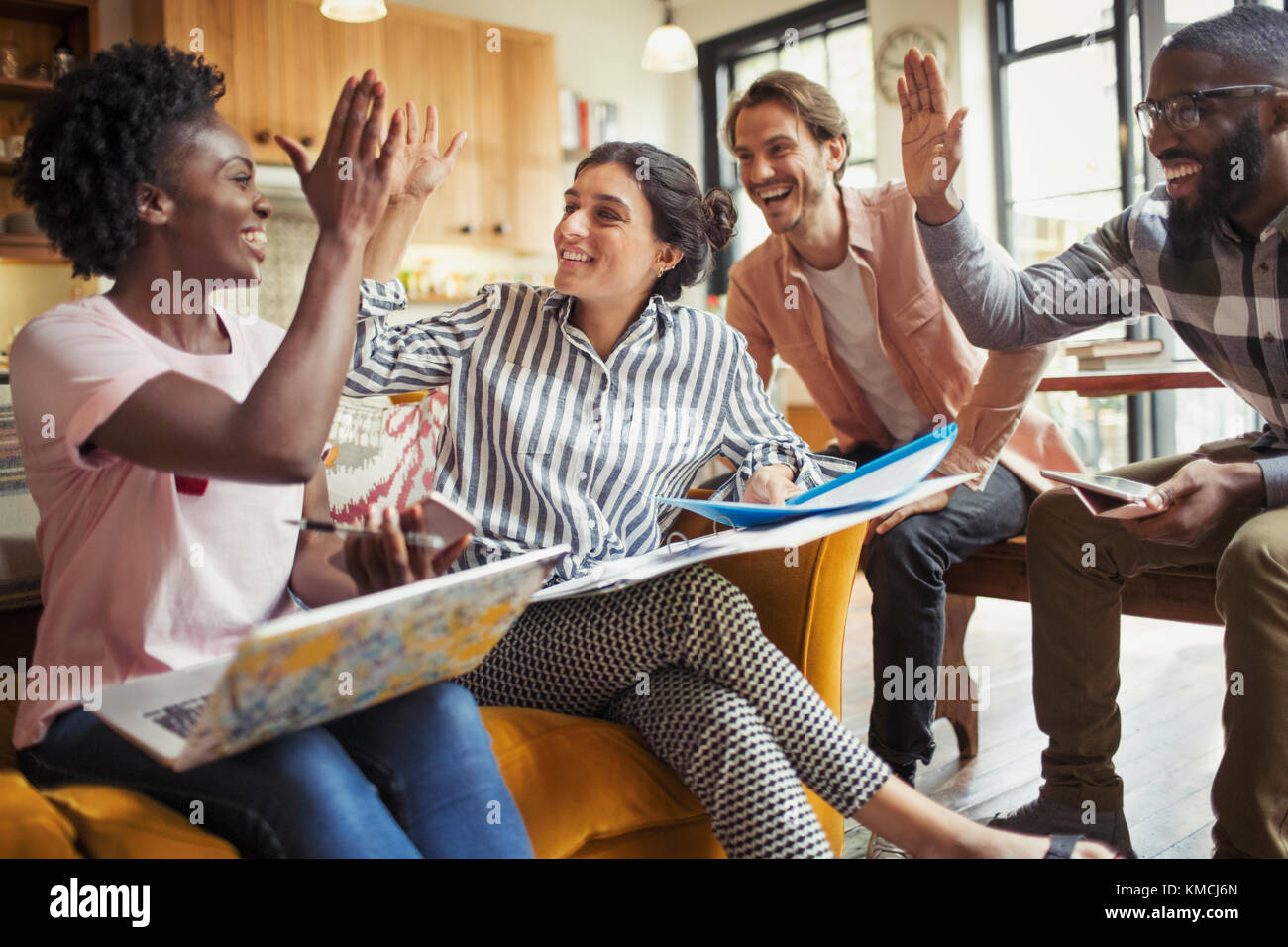 Creative business people high-fiving in meeting Stock Photo - Alamy