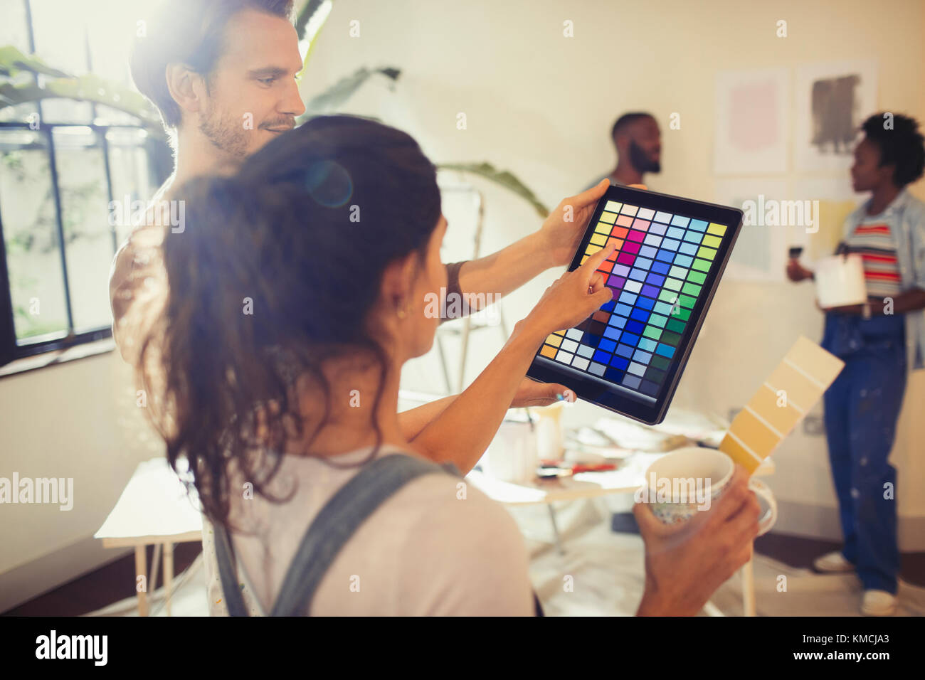 Friends with digital tablet viewing digital paint swatches, painting ...