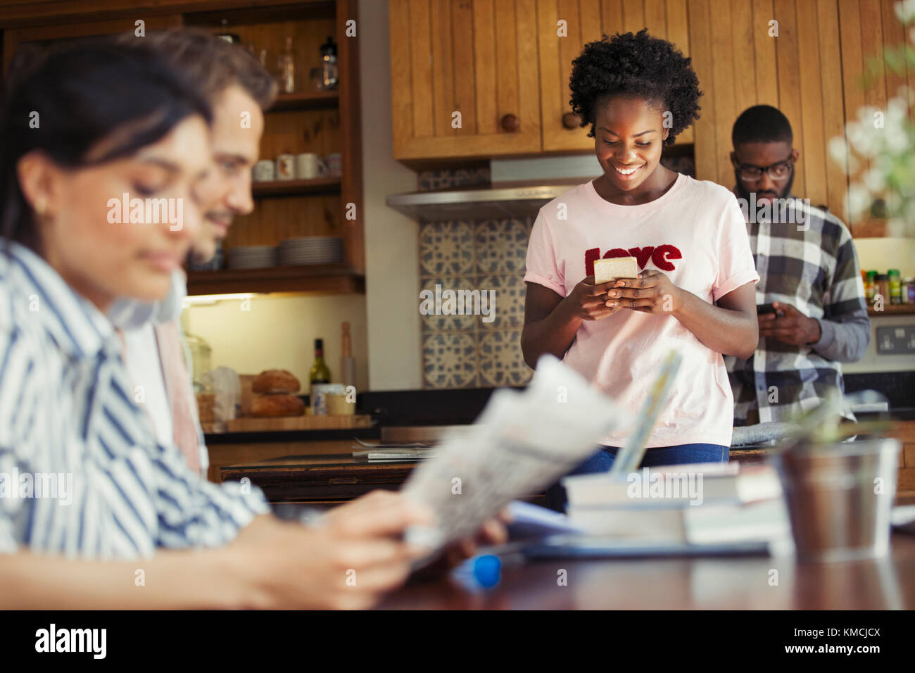 Woman texting with smart phone in kitchen Stock Photo - Alamy