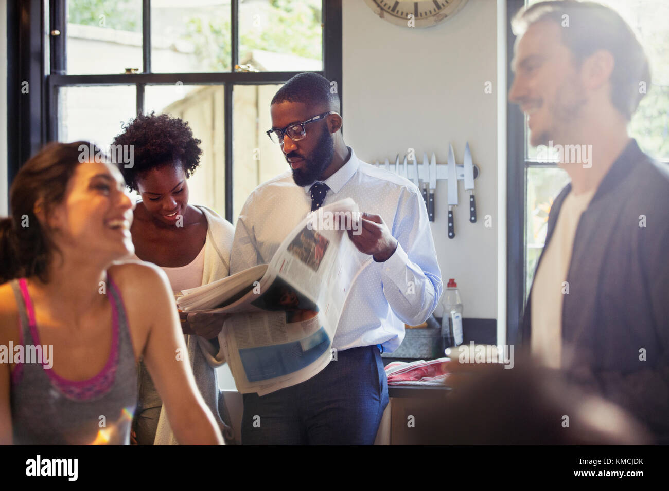 Friend roommates talking and reading newspaper in morning kitchen Stock ...