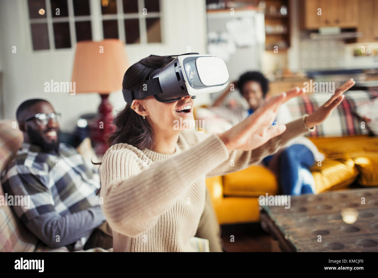 Woman gesturing, using virtual reality simulator glasses in living room ...