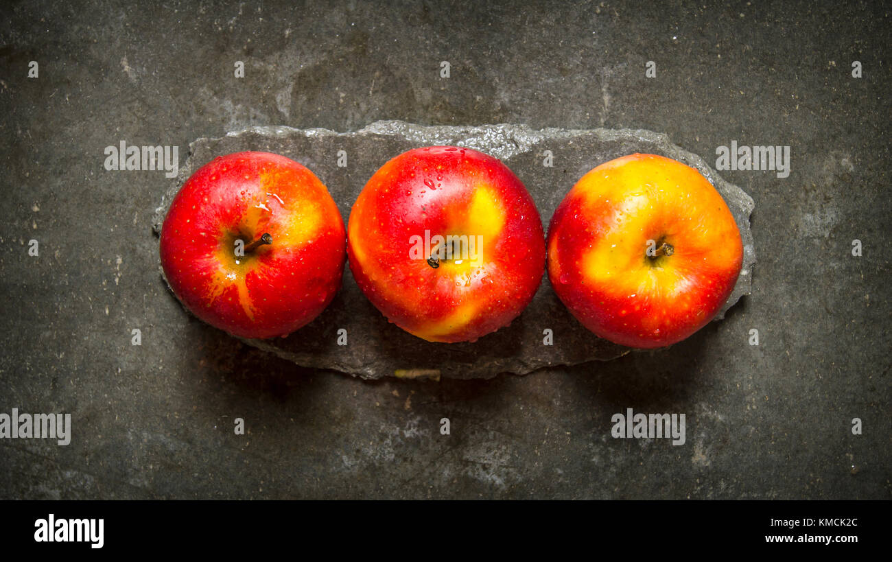 Fresh red apples on a stone stand. On a rustic stone table. Top view ...