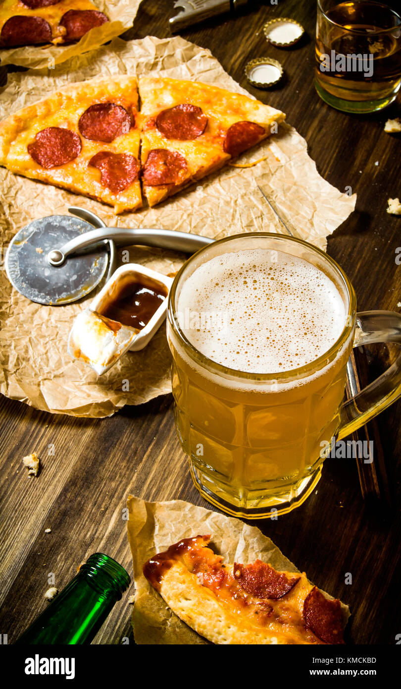 The concept of pizza with beer. Pepperoni pizza with beer on a wooden ...