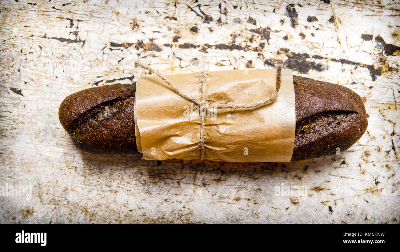 Rye bread wrapped in paper. On a rustic background Stock Photo - Alamy