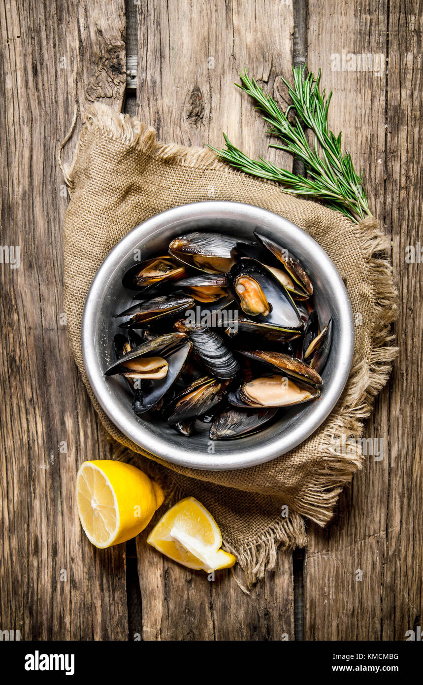 Cup with clams, Limon and rosemary. On a wooden table. Top view Stock ...