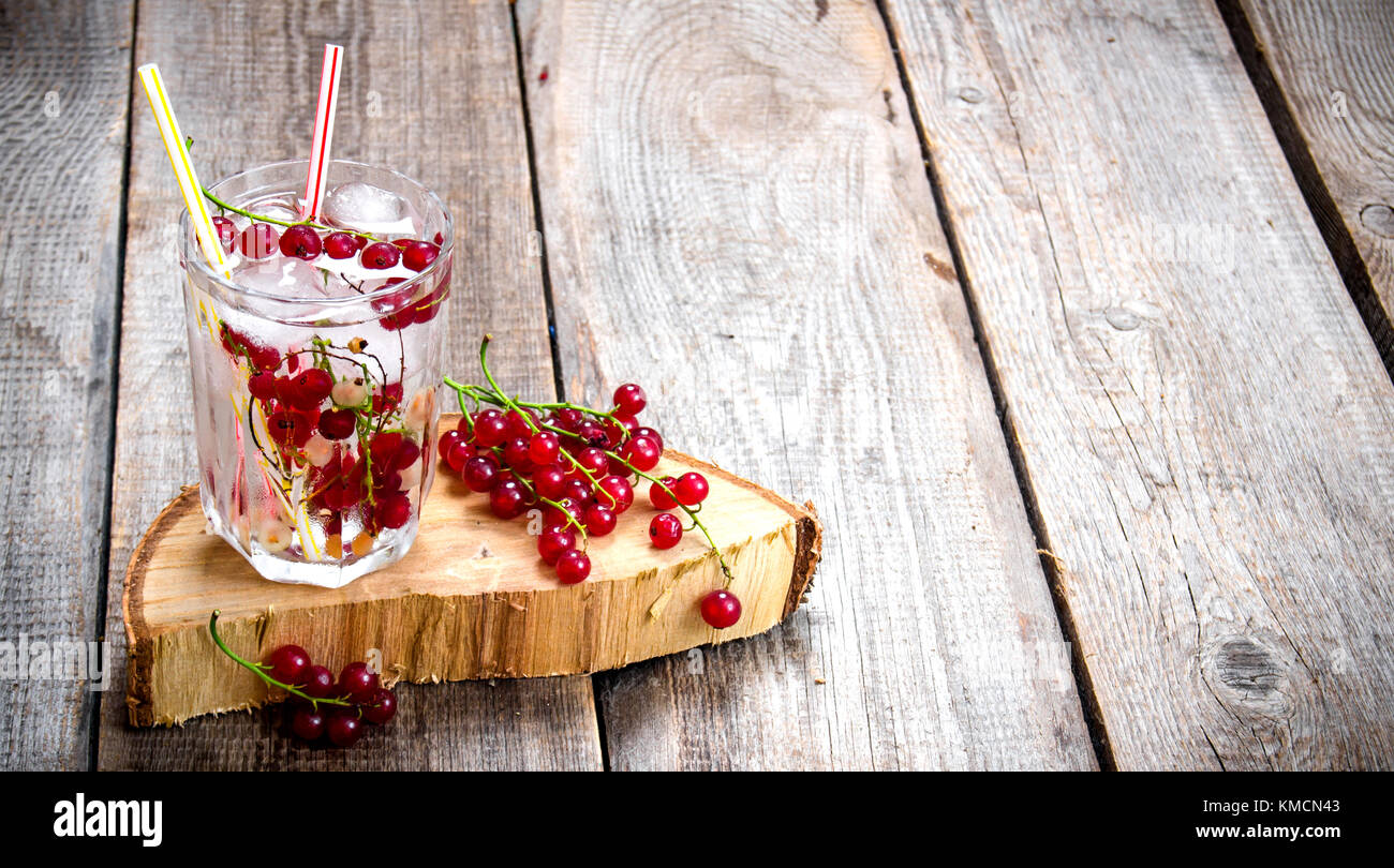 Cocktail currants . A cocktail of wild currant with ice on a wooden ...