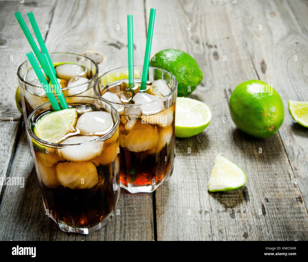 Cuba Libre cocktail . Fresh cocktail with lime and mint on wooden table ...