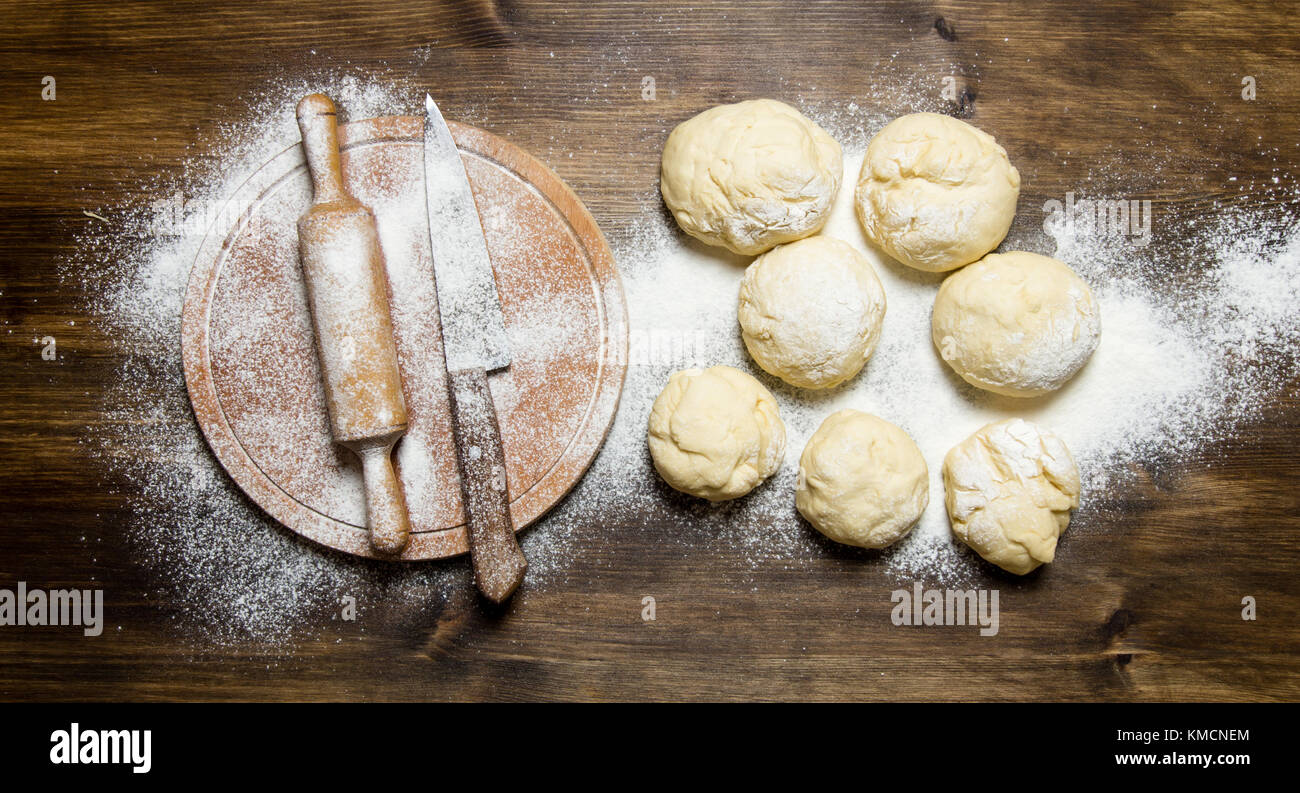 Preparation of the dough. The prepared dough with a rolling pin and ...
