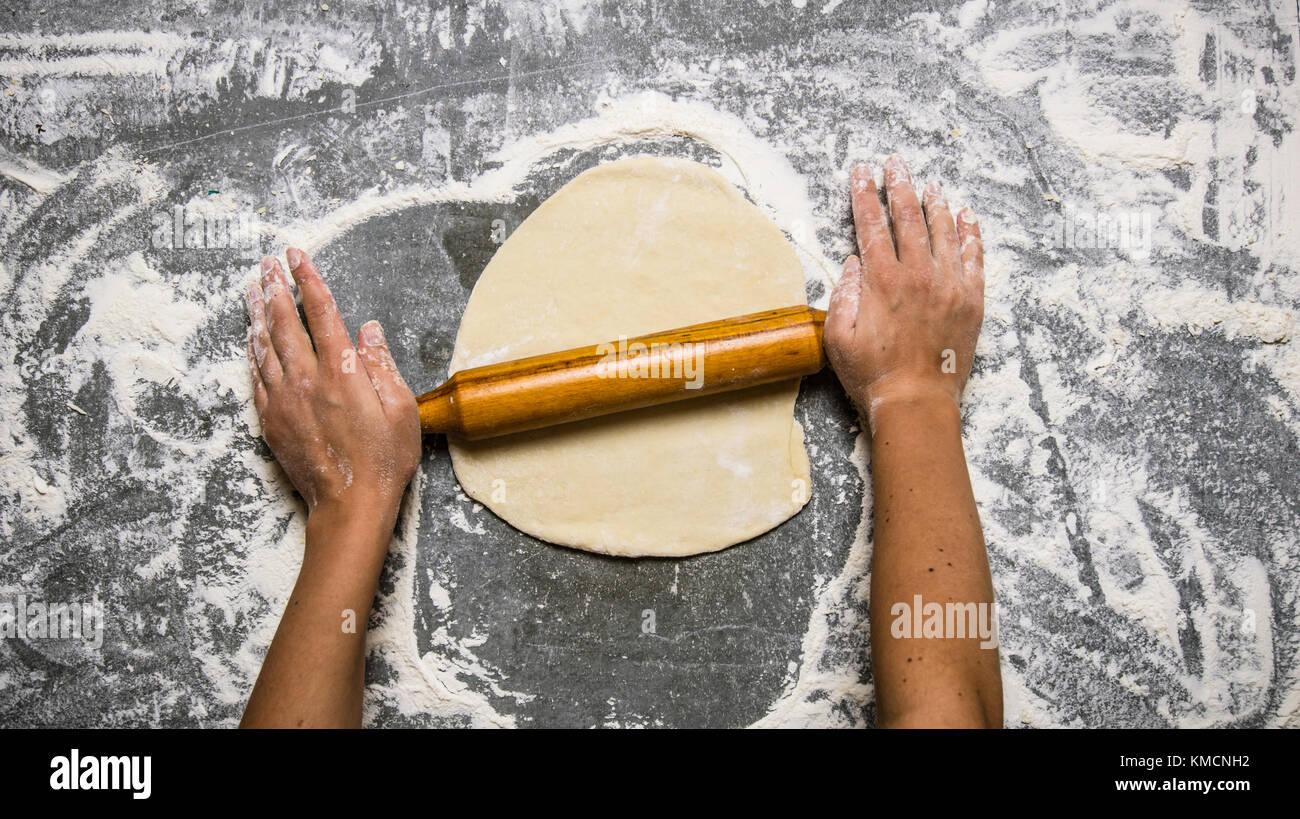Preparation of the dough . The dough rolling the women's hands. On the ...