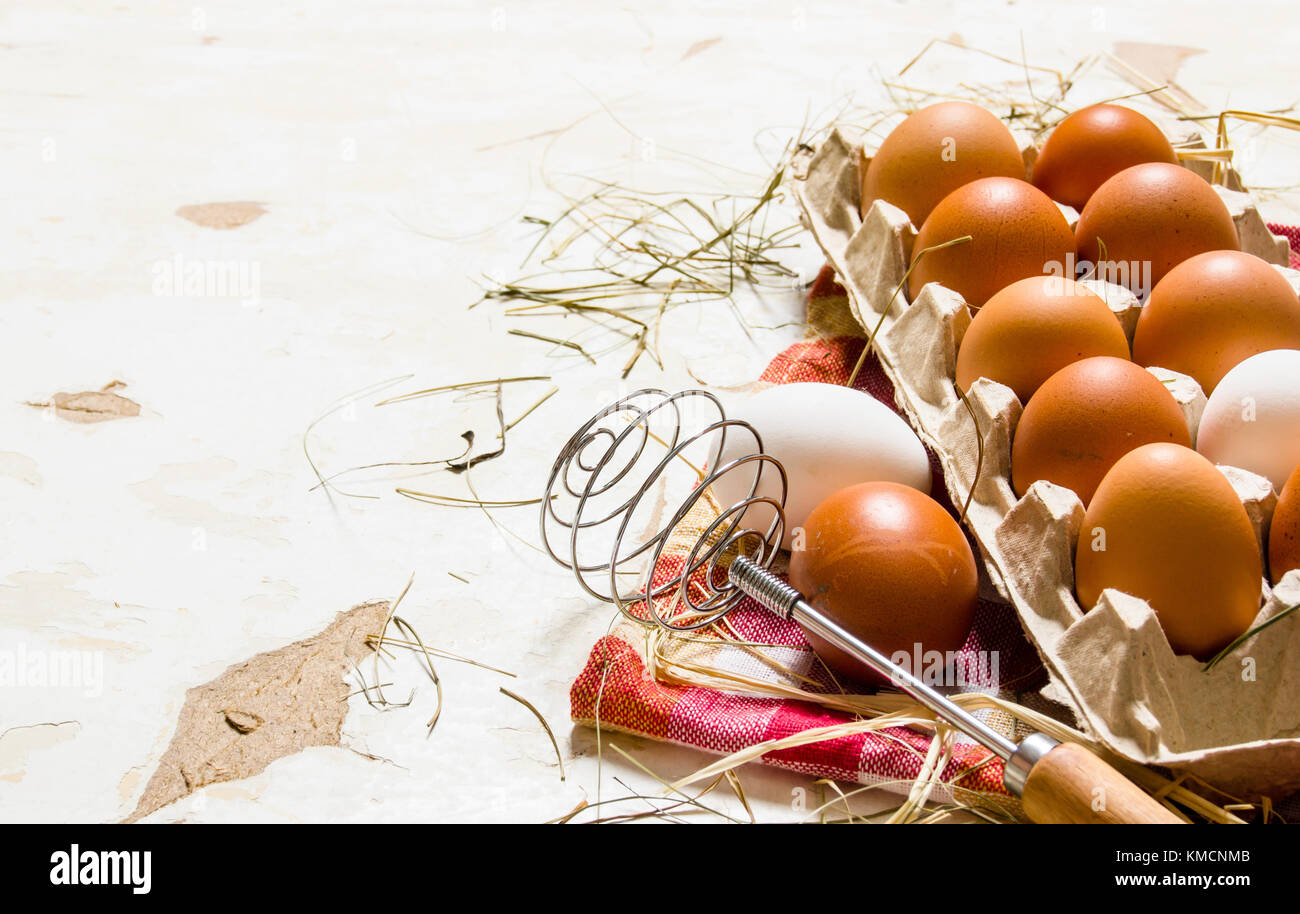 The cassette with eggs, hay and whisk on the fabric. On rustic ...