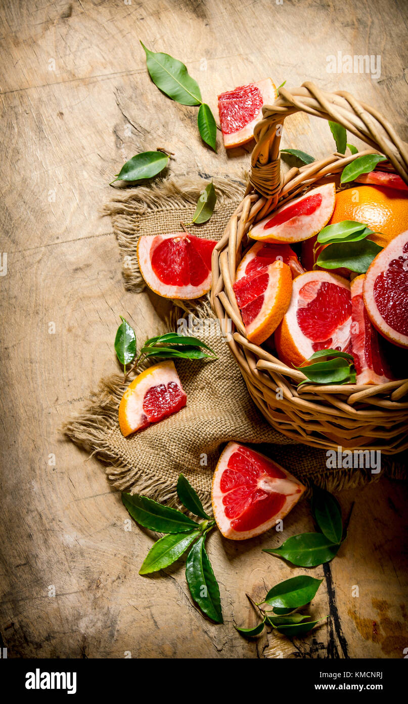 Grapefruit background. Grapefruit sliced in the old basket with leaves ...