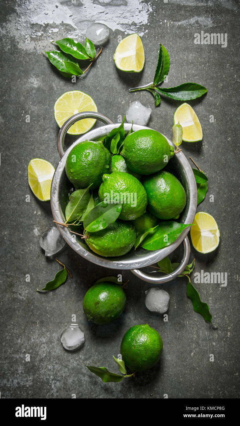 Lime background. Fresh limes in a saucepan with slices and leaves ...