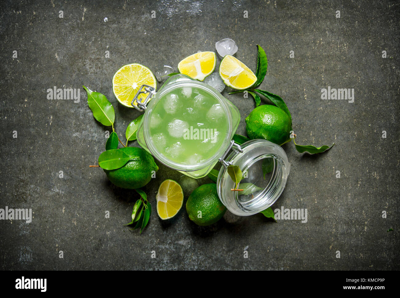 Lime background. The juice from the limes with ice and sliced limes ...