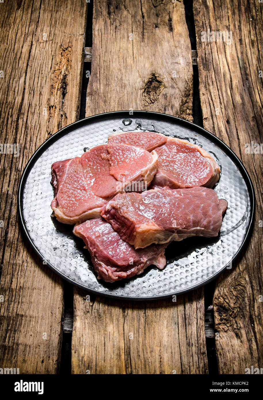 Fresh raw meat on a stand. On the wooden background Stock Photo - Alamy
