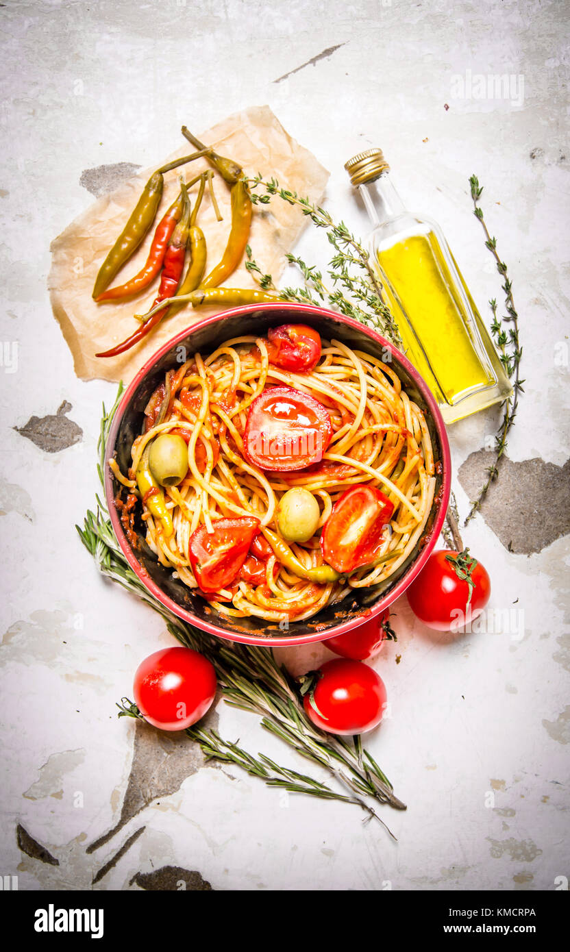 Spaghetti with tomato paste, hot Chili peppers and olive oil. On rustic ...