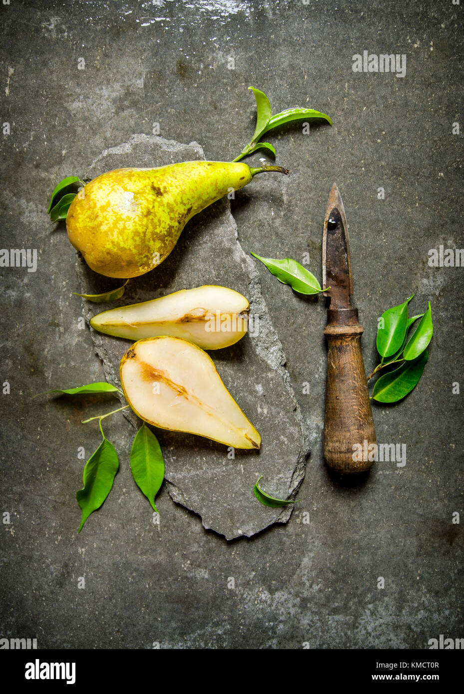 Fresh pears on a stone stand with leaves. On the stone table. Top view ...