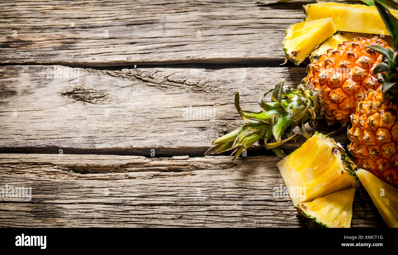 Fresh sliced pineapple with whole. On the wooden background. Free space ...