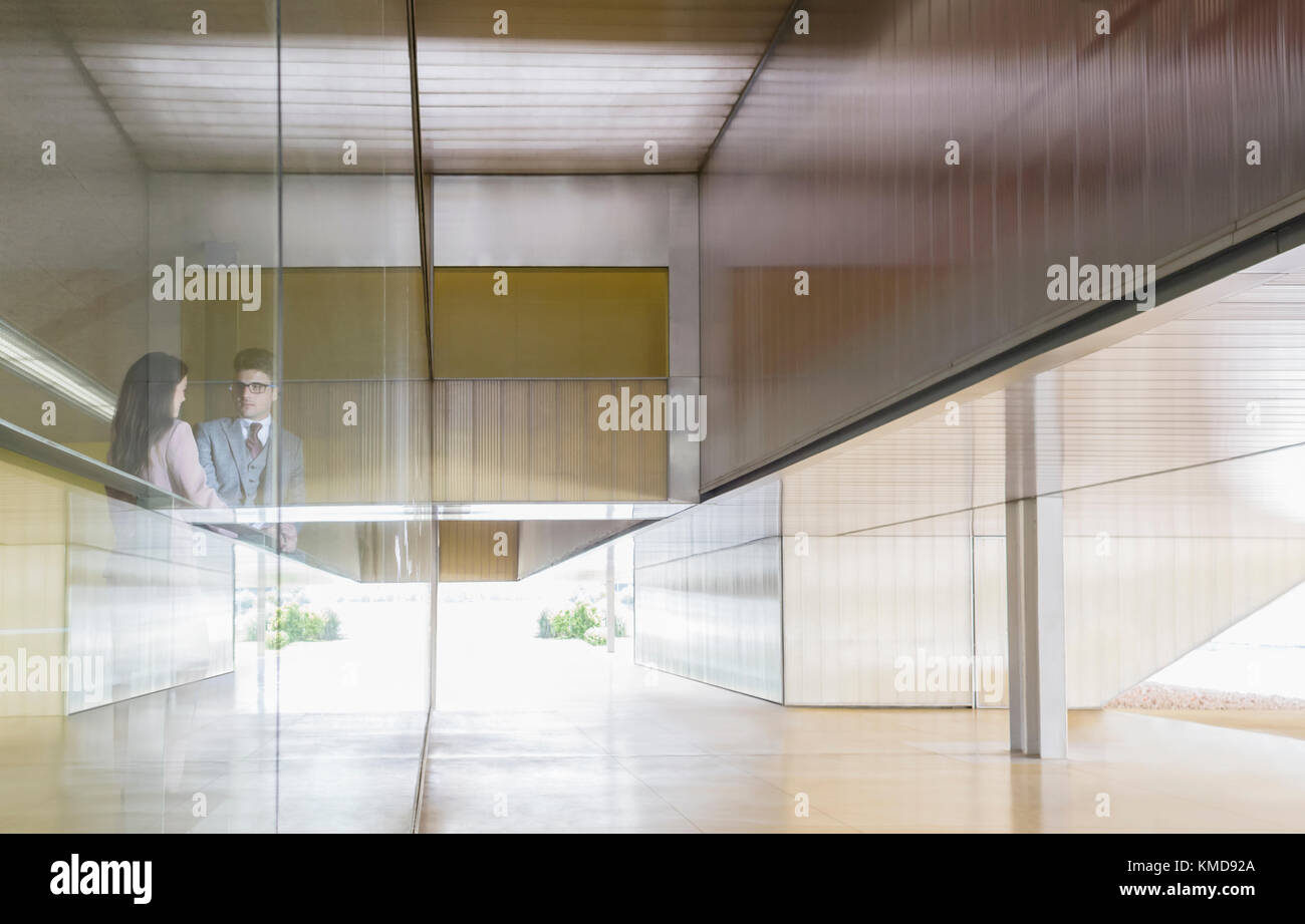 Business people talking at window in modern office lobby Stock Photo ...