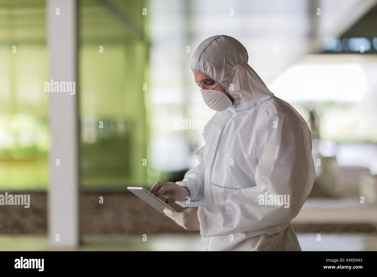 Scientist in clean suit using digital tablet Stock Photo - Alamy